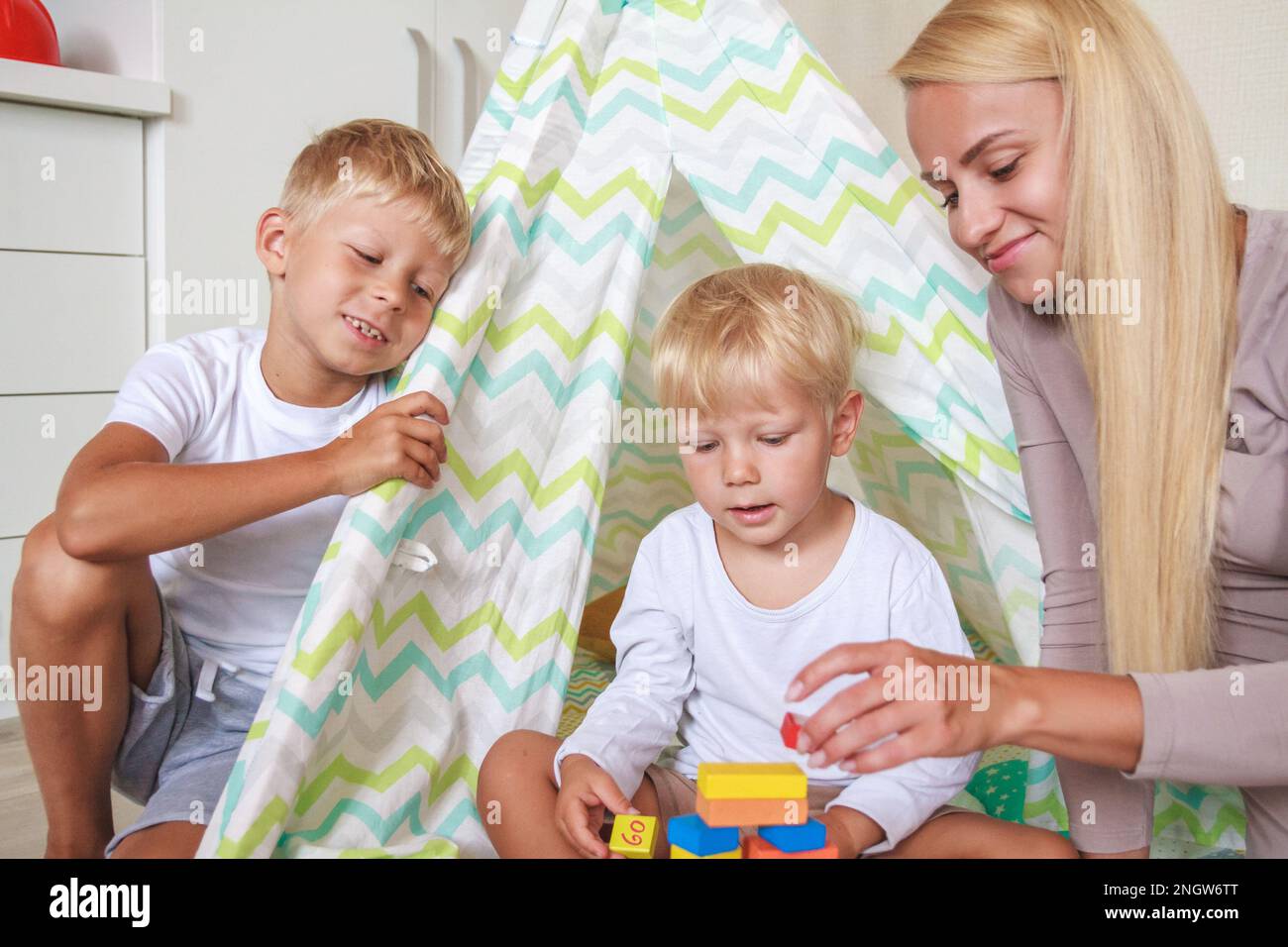 Mom and son build a tower together from constructor Stock Photo - Alamy