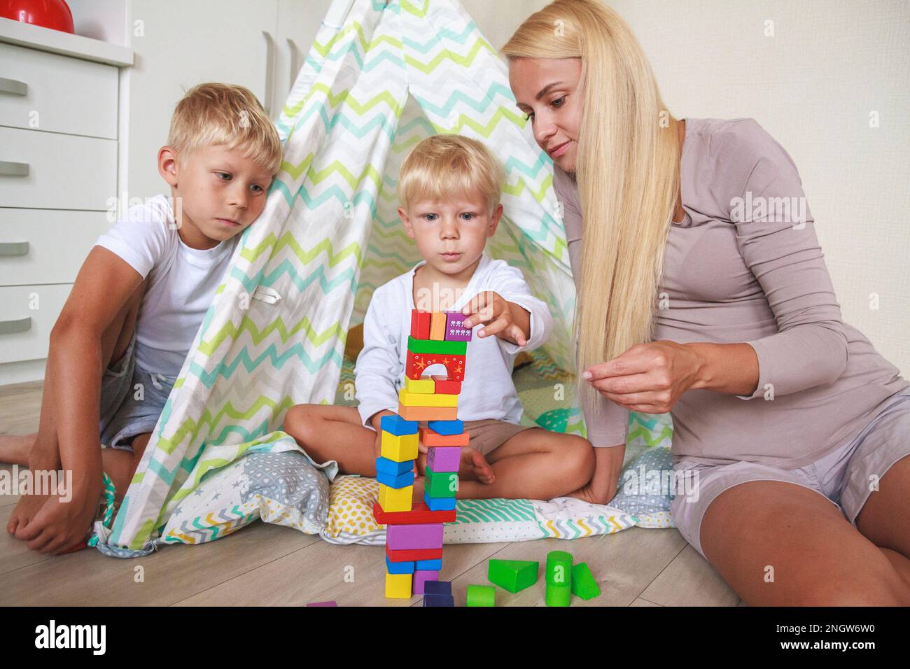 Mom and son build a tower together from constructor Stock Photo - Alamy