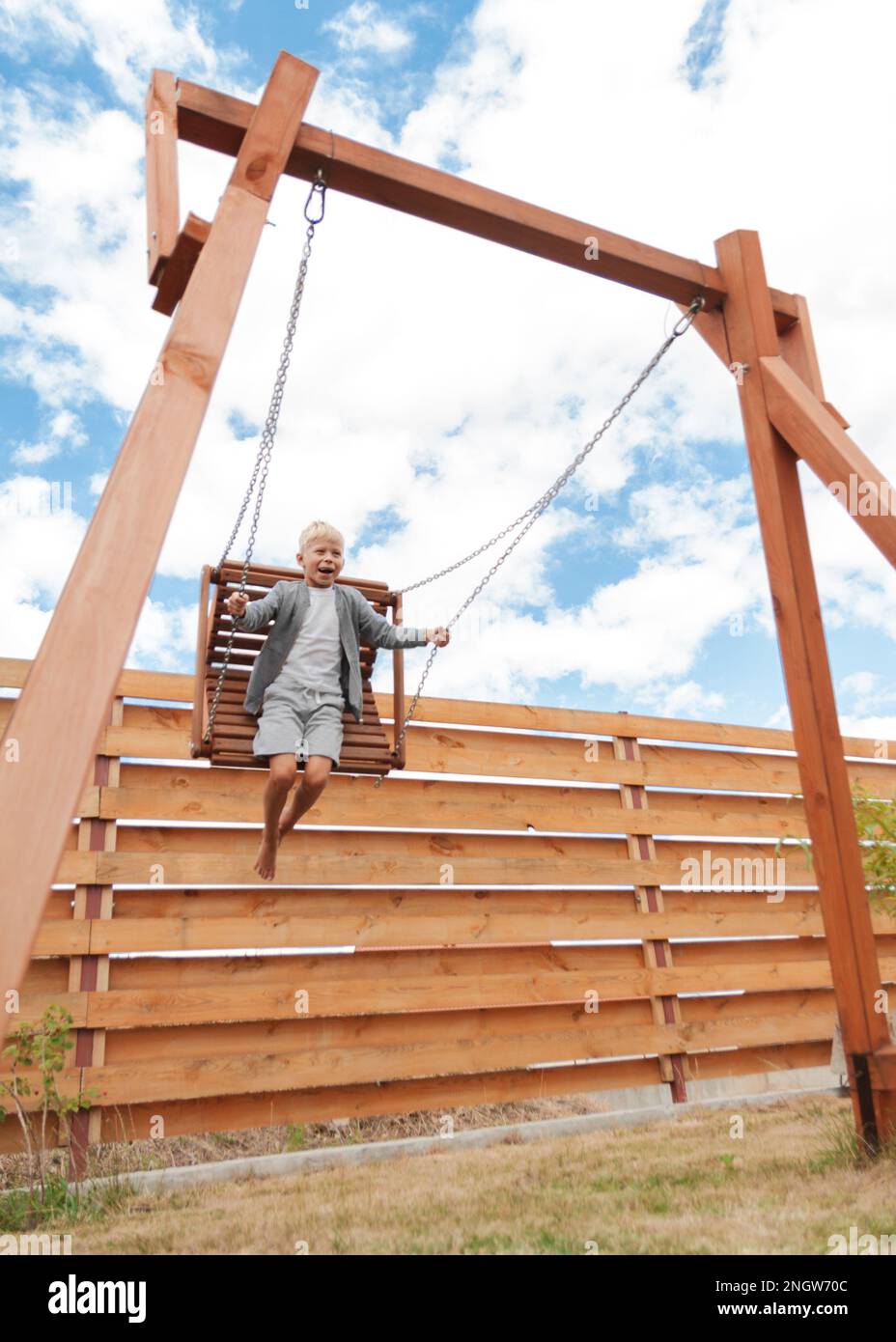 Kid toddler boy swinging on a playground swing in the backyard a Stock ...