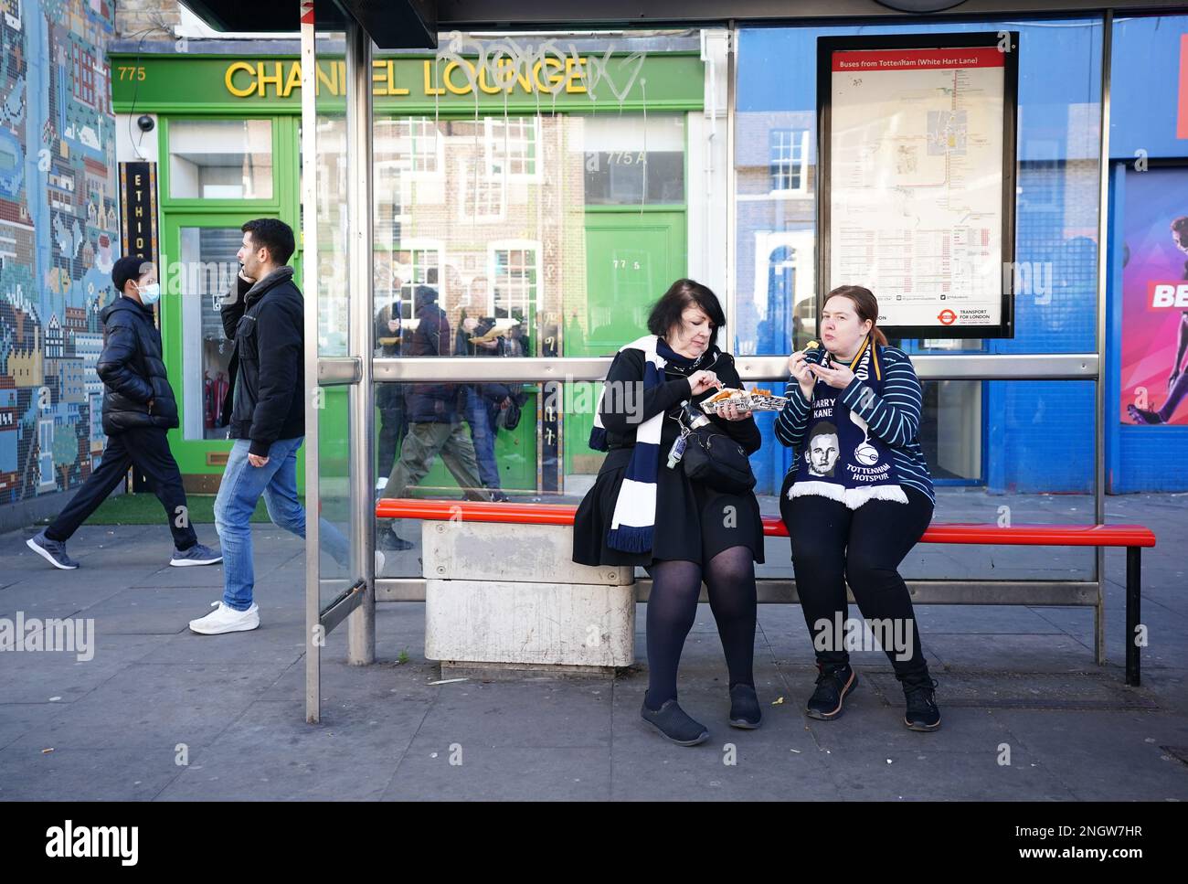 Tottenham Hotspur fans sit at a bus-stop ahead of the Premier League ...