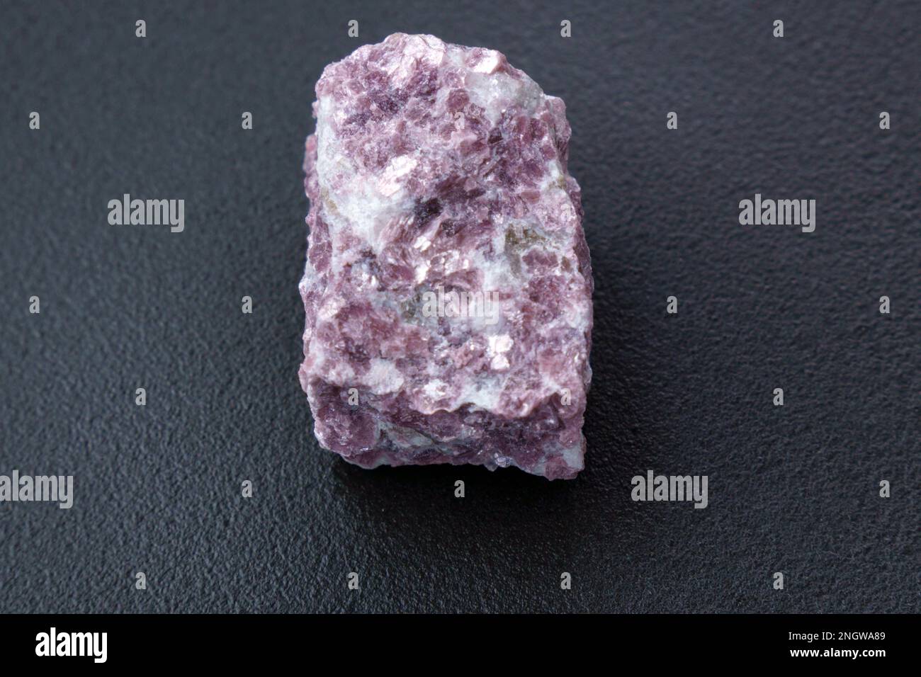 Lepidolite stone on a black background, being a secondary source of ...