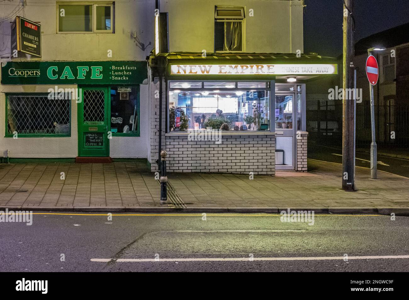 Chinese takeaway at night in a suburban high street with customers ...