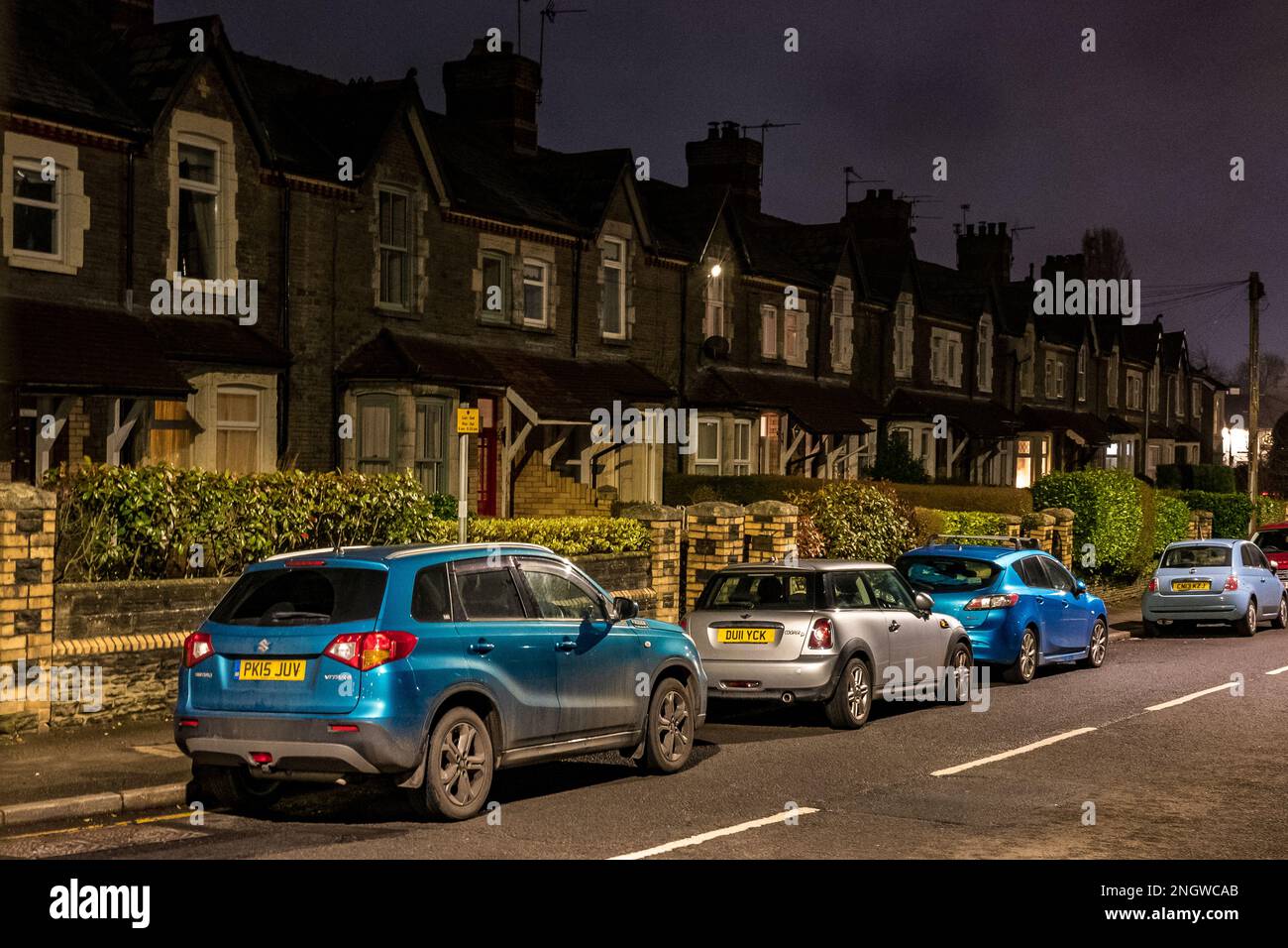 Street of middle-class terraced houses with cars parked on the street ...