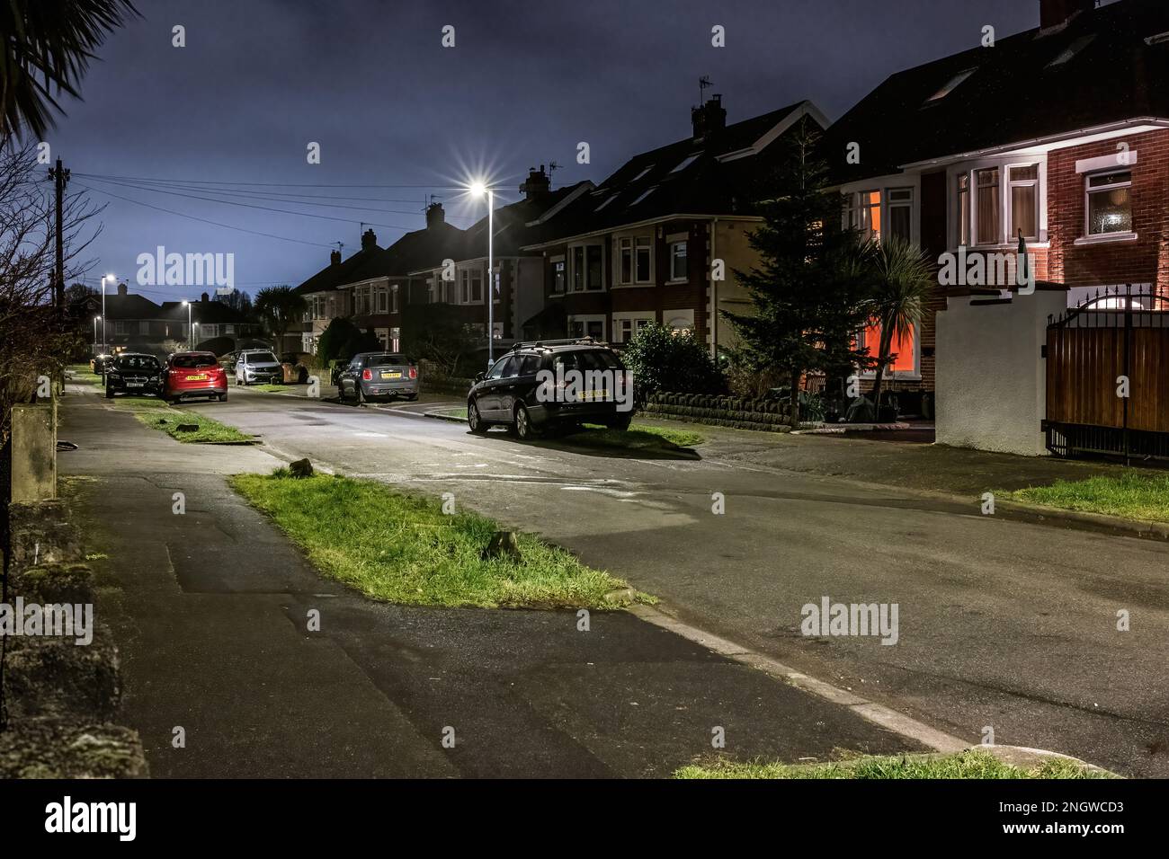 Street of middle-class houses with cars parked on the street in ...