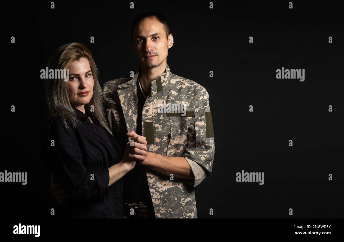 Happy woman hugging his husband came back from army. Smiling cheerful ...