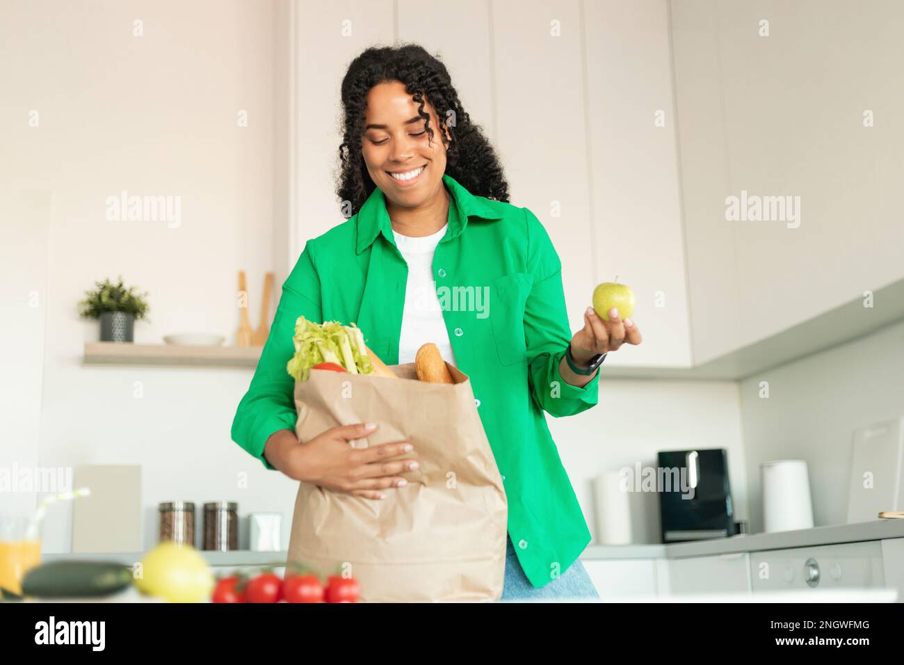 Black Lady Unpacking Paper Grocery Bag After Shopping In Kitchen Stock ...