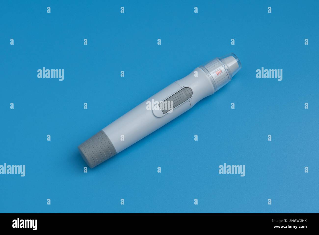 A lancet pen is isolated on blue background. Treatment diabetes and ...