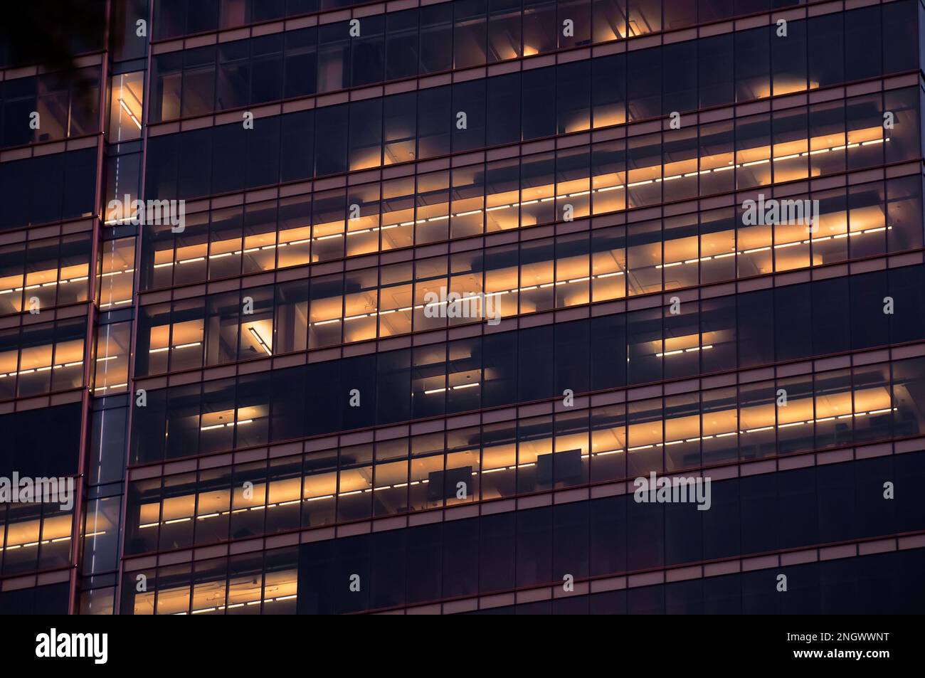 Urban geometry. Night view on glassy wall of high-rise building with ...