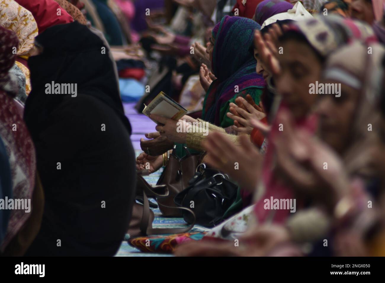 Muslim women raise their hands in prayers as the head cleric (unseen ...