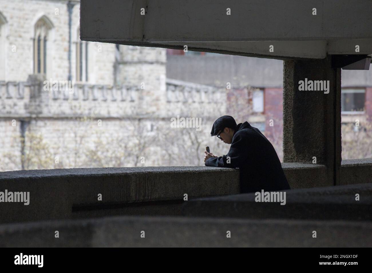 Lone tourist taking photos at the Barbican Centre London Stock Photo ...