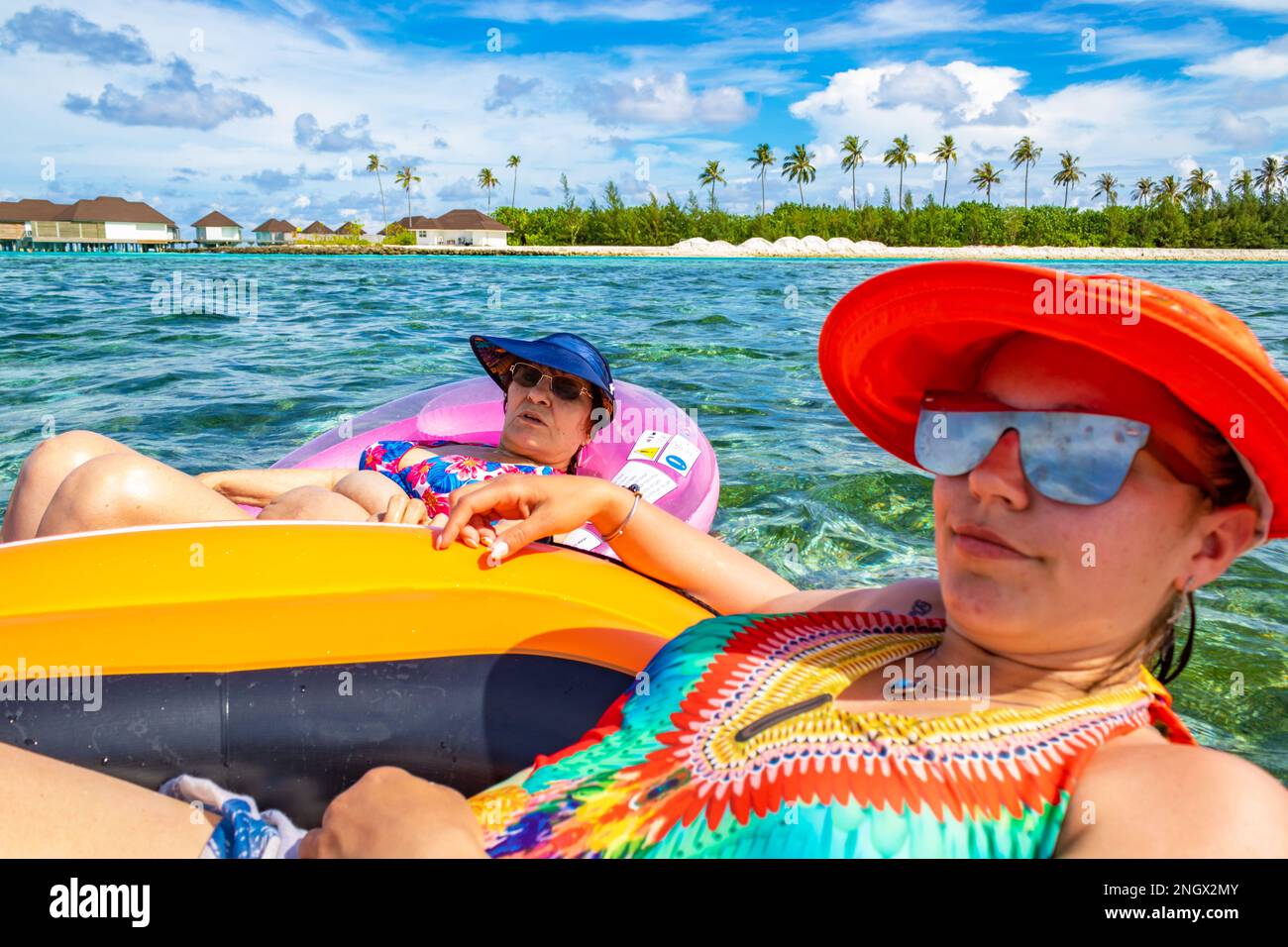 Senior and young women sail in an inflatable boat by Bodufinolhu island ...