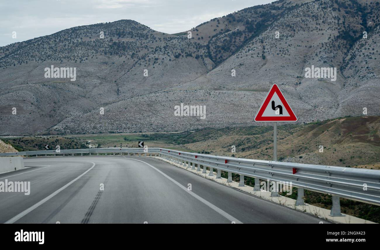Left Reverse Bend Road Sign on the mountain Road in albania Stock Photo ...