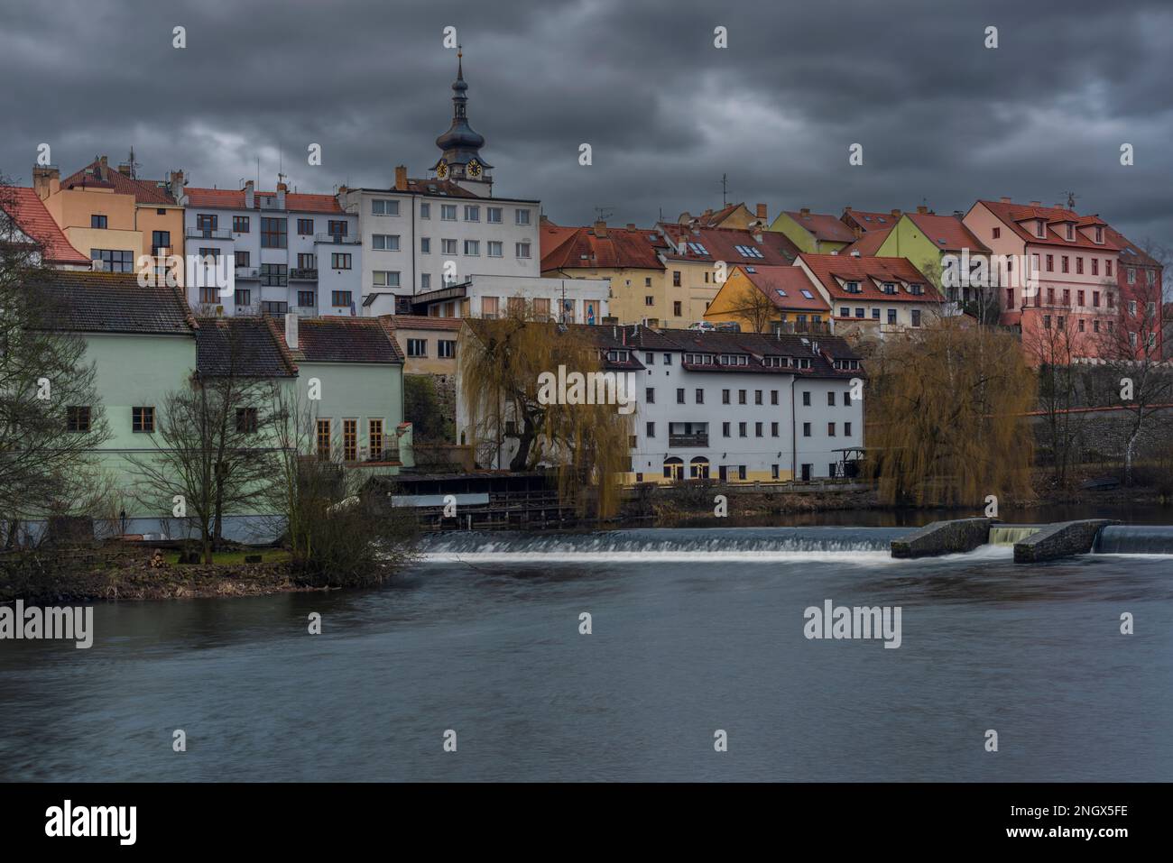 Old stone bridge and center of Pisek town in cloudy winter windy ...