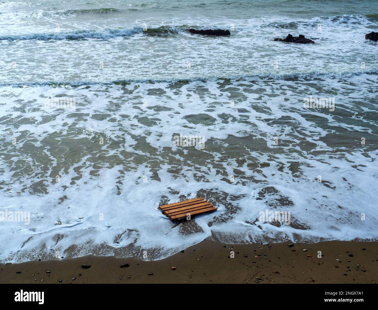 Waves on the beach with wood in the foreground Stock Photo - Alamy
