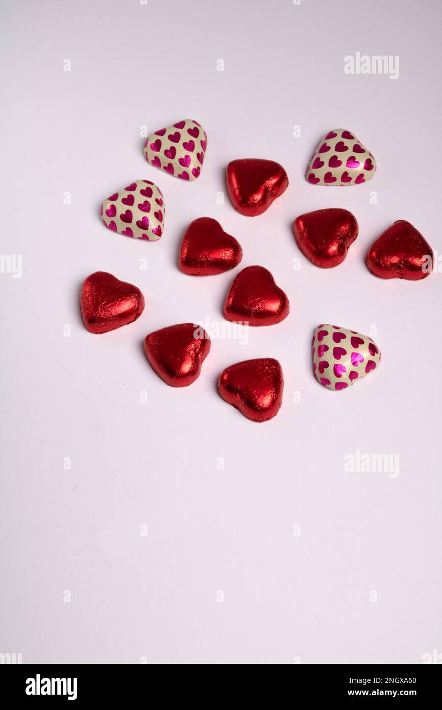 photo chocolate hearts in a colorful wrapper on a white background ...