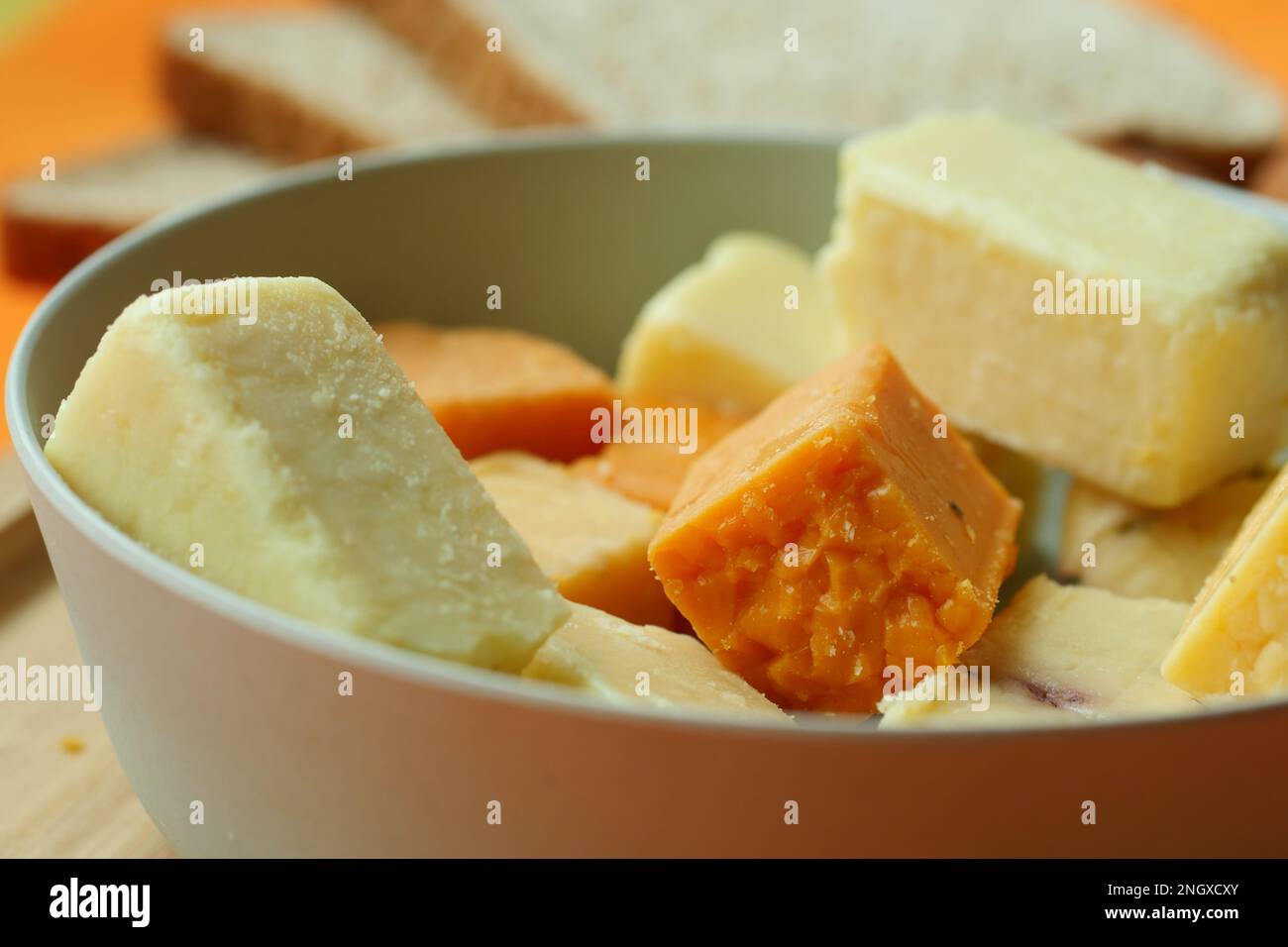Cheese cubes green, yellow and red color on chopping board Stock Photo ...