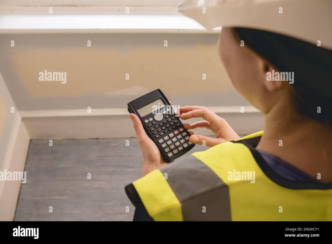 Unrecognizable civil engineer woman calculating with a calculator in a ...