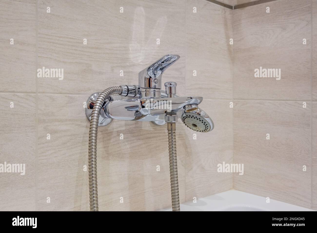 water tap and shower in bathroom on wall with tiles Stock Photo - Alamy