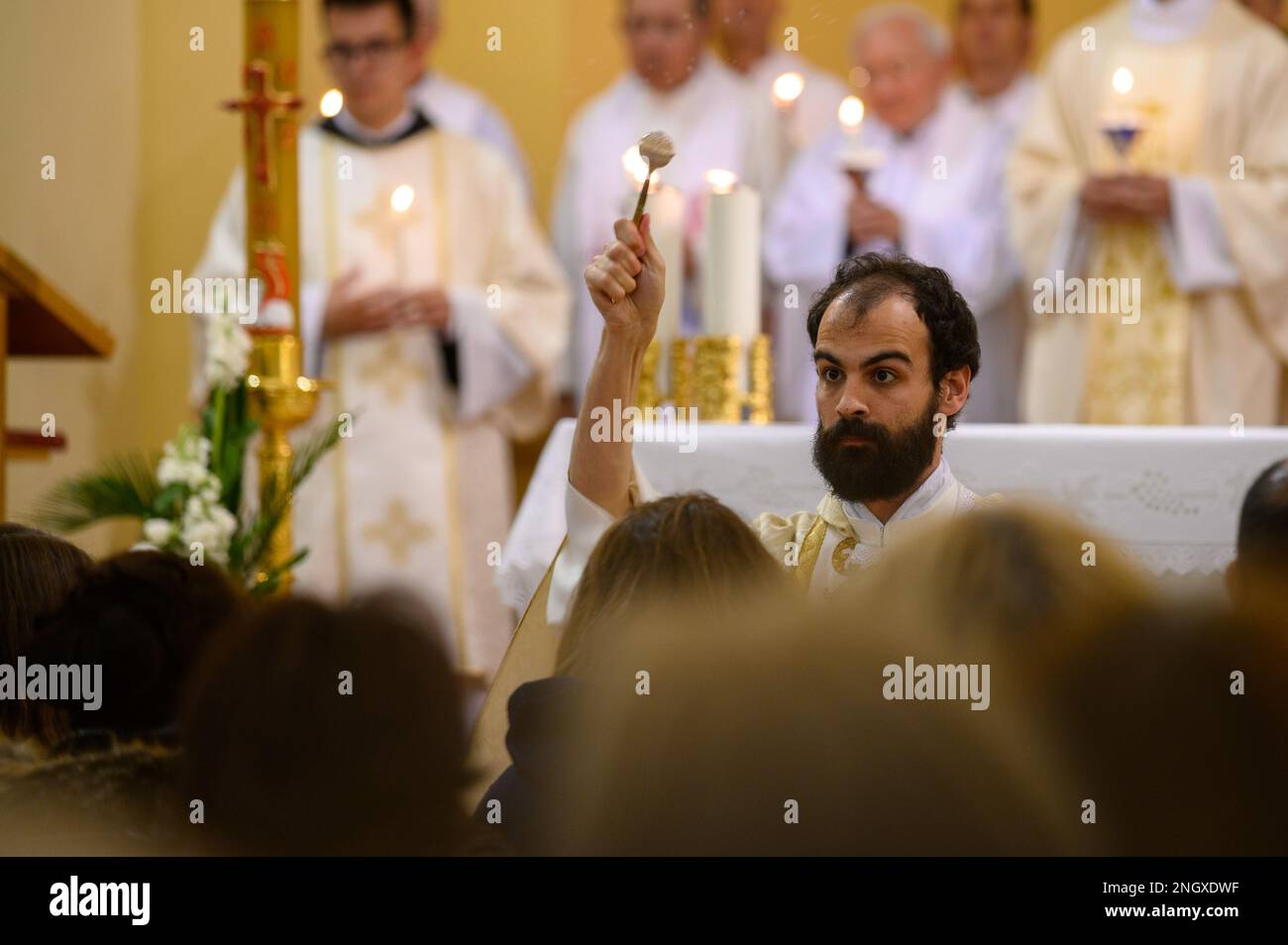 A priest blessing the faithful with holy water on the Easter Vigil in ...