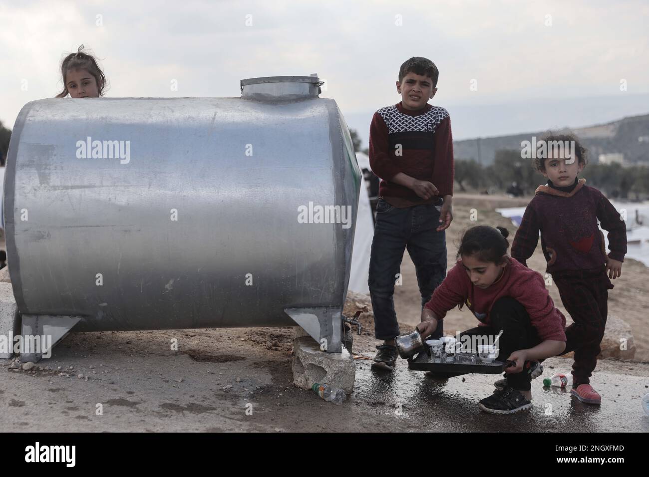 Salqin, Syria. 19th Feb, 2023. A girl washes dishes at an emergency ...