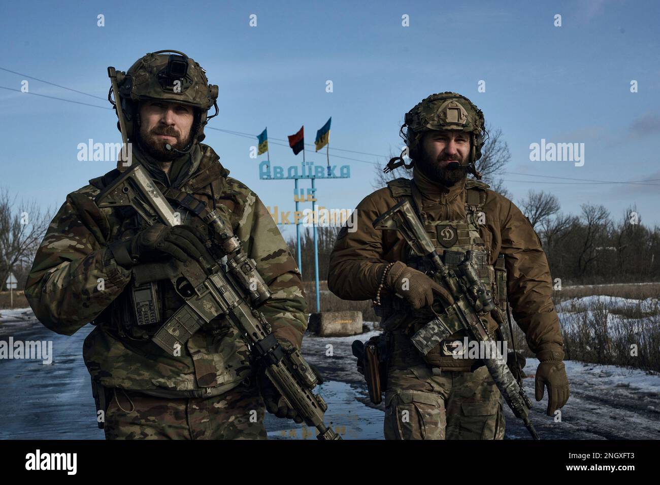 Ukrainian soldiers walk against the background of a sign reading ...
