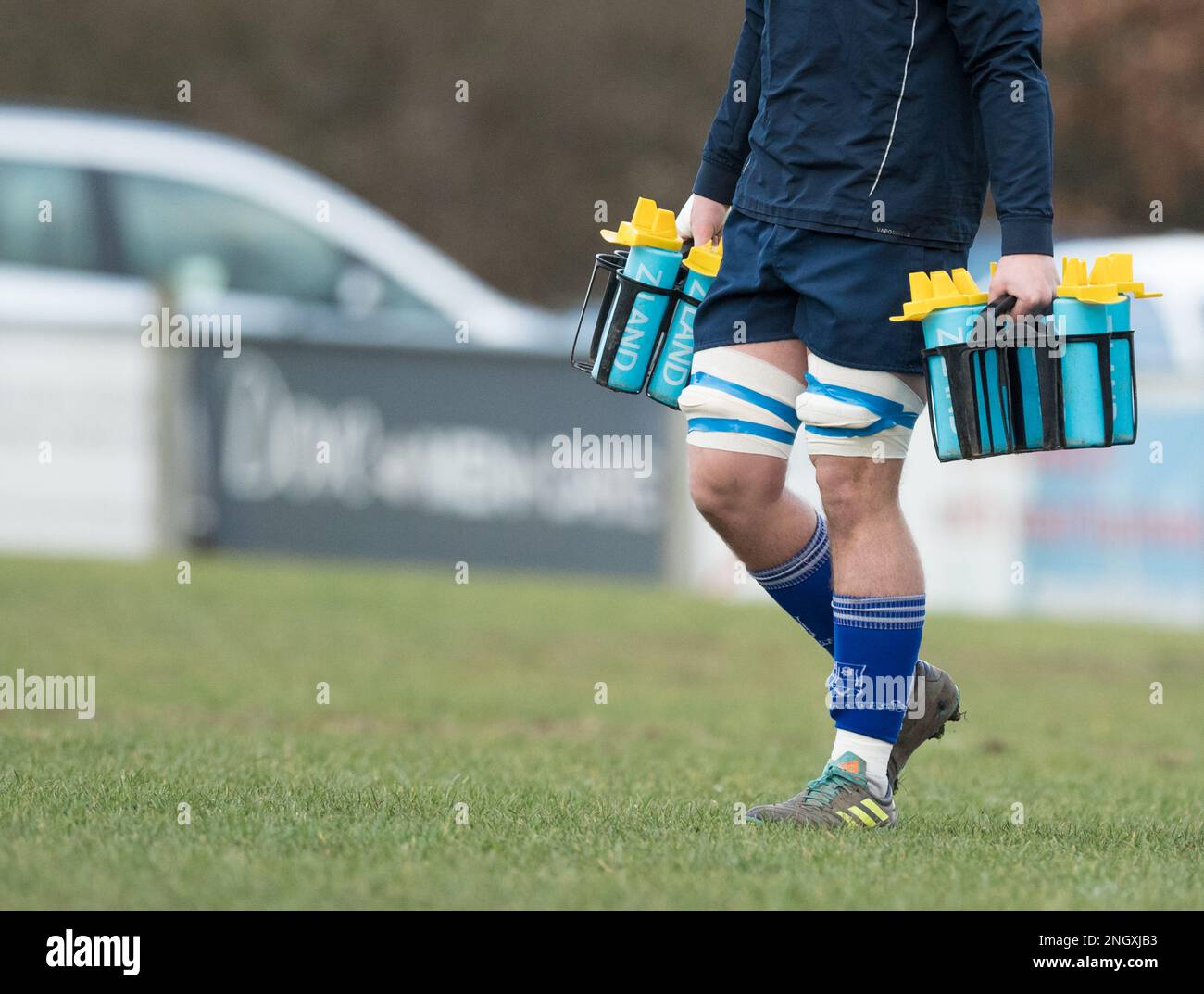 Rugby support team member carrying Ziland water bottles Stock Photo - Alamy
