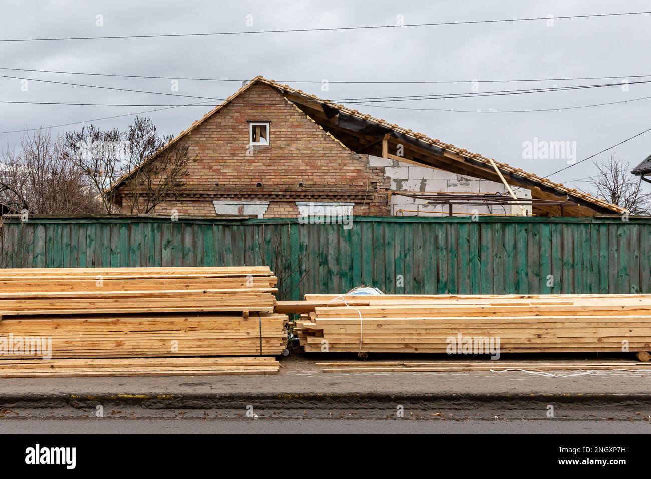 Pieces of wood lie on the pavement ready to rebuild a bombarded house ...