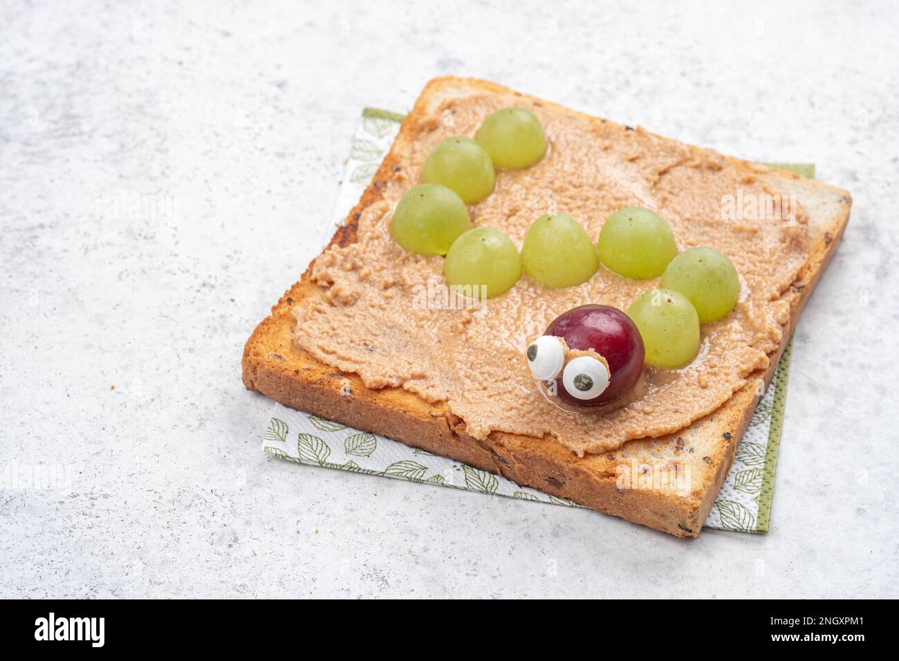 Funny worm sandwich with peanut butter and grapes Stock Photo - Alamy