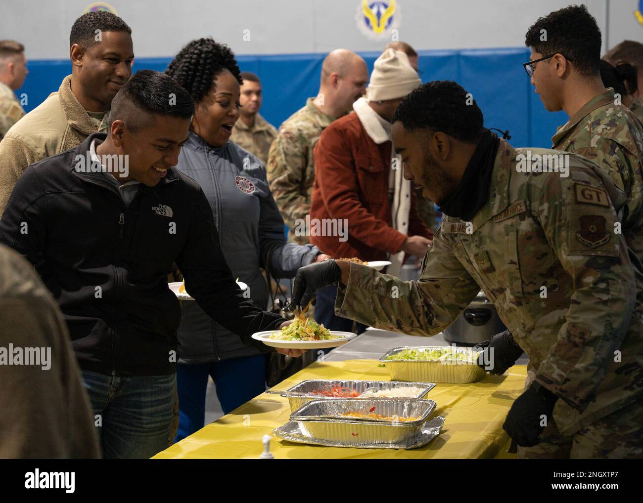 Members of Team Minot make their way through a serving line during a ...