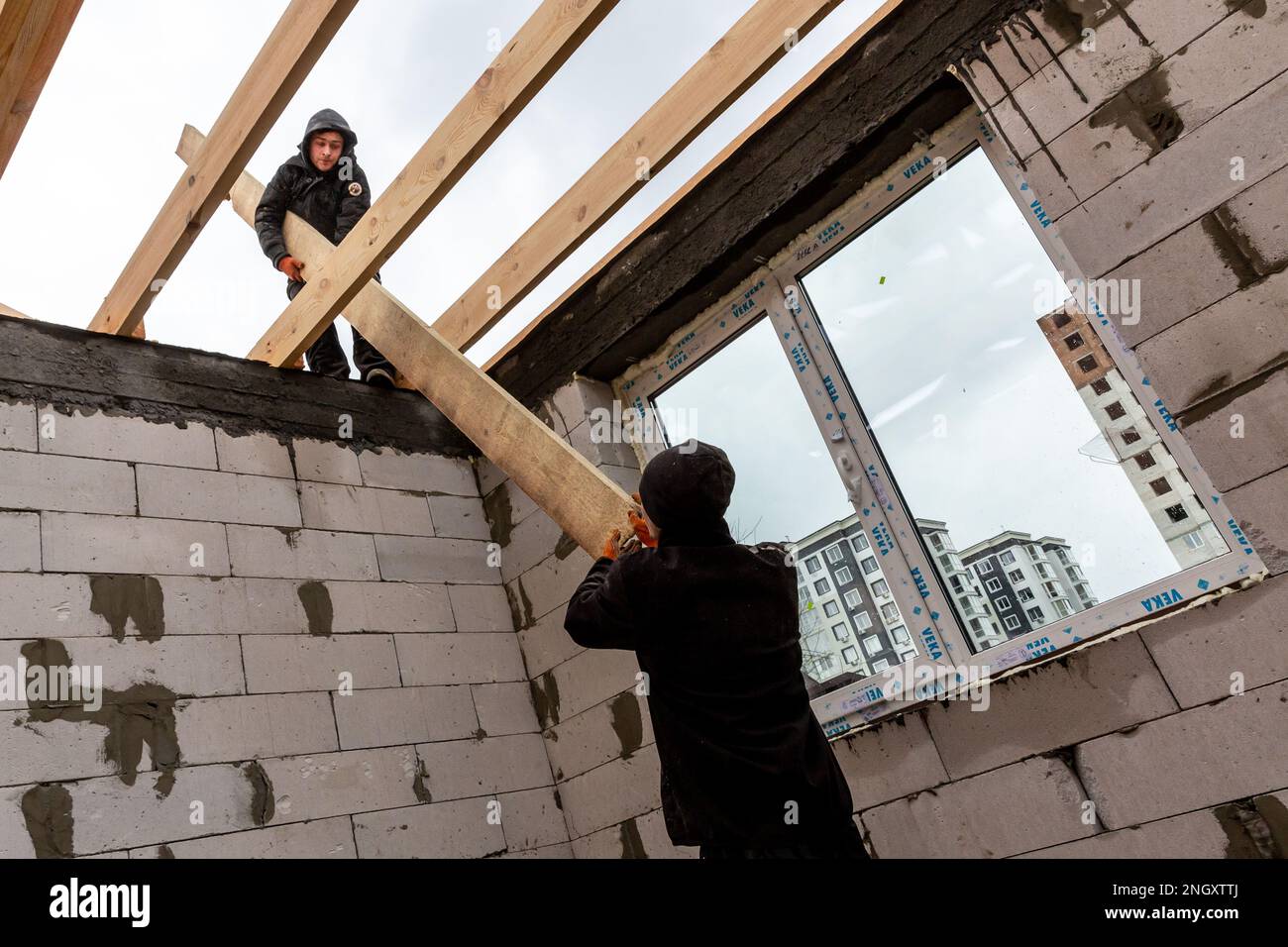 Bucha, Kyiv Oblast, Ukraine. 18th Feb, 2023. Builders work on a roof on ...