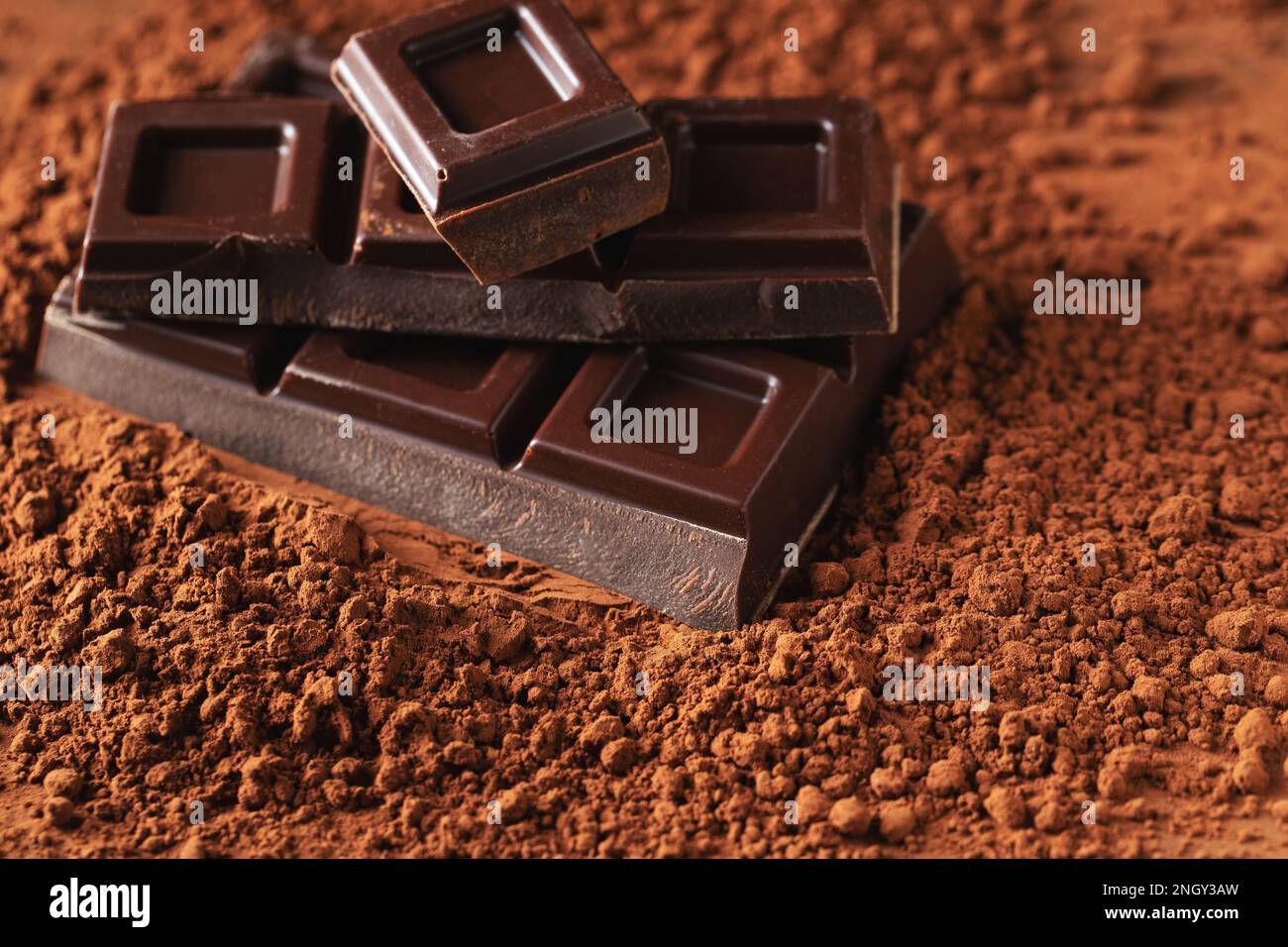 Dark and milk chocolate with nuts on a dark background sprinkled with ...