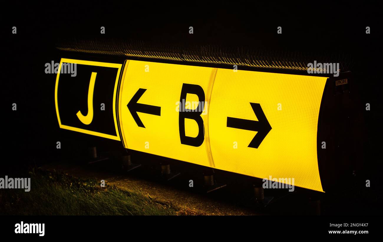 A taxiway direction sign illuminates the grass Dec. 1, 2022, at the ...