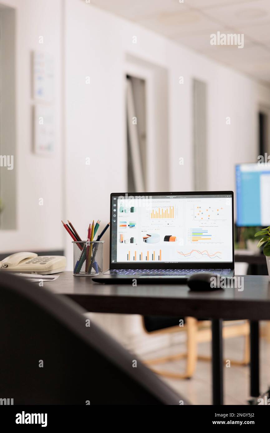 Portable computer executing cost analysis software on the office desk ...