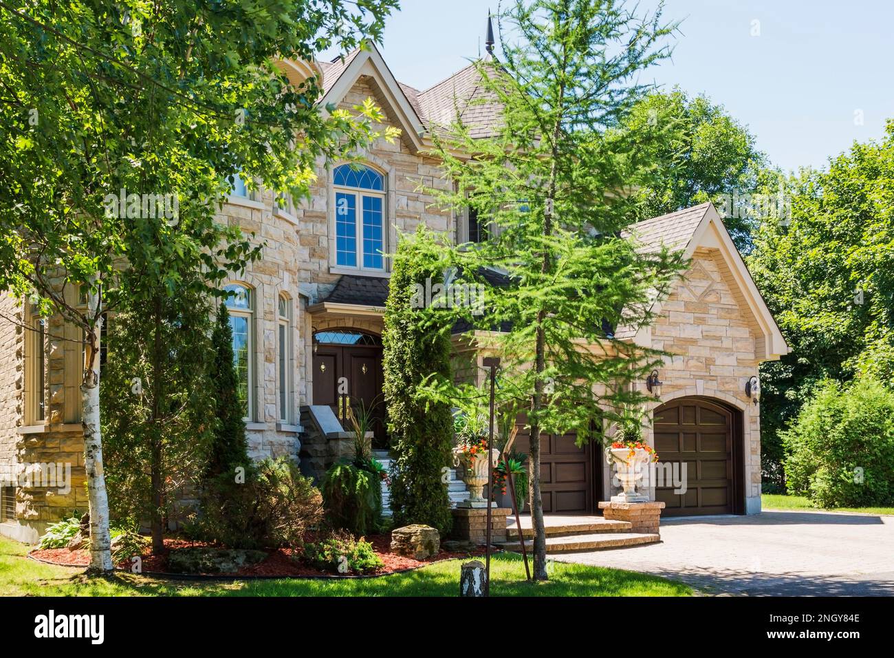 Beige and tan cut stone with tan trim luxurious house facade in summer ...