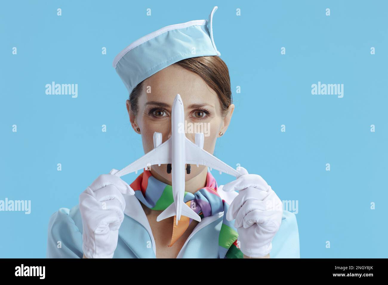 stylish female air hostess against blue background in blue uniform with ...