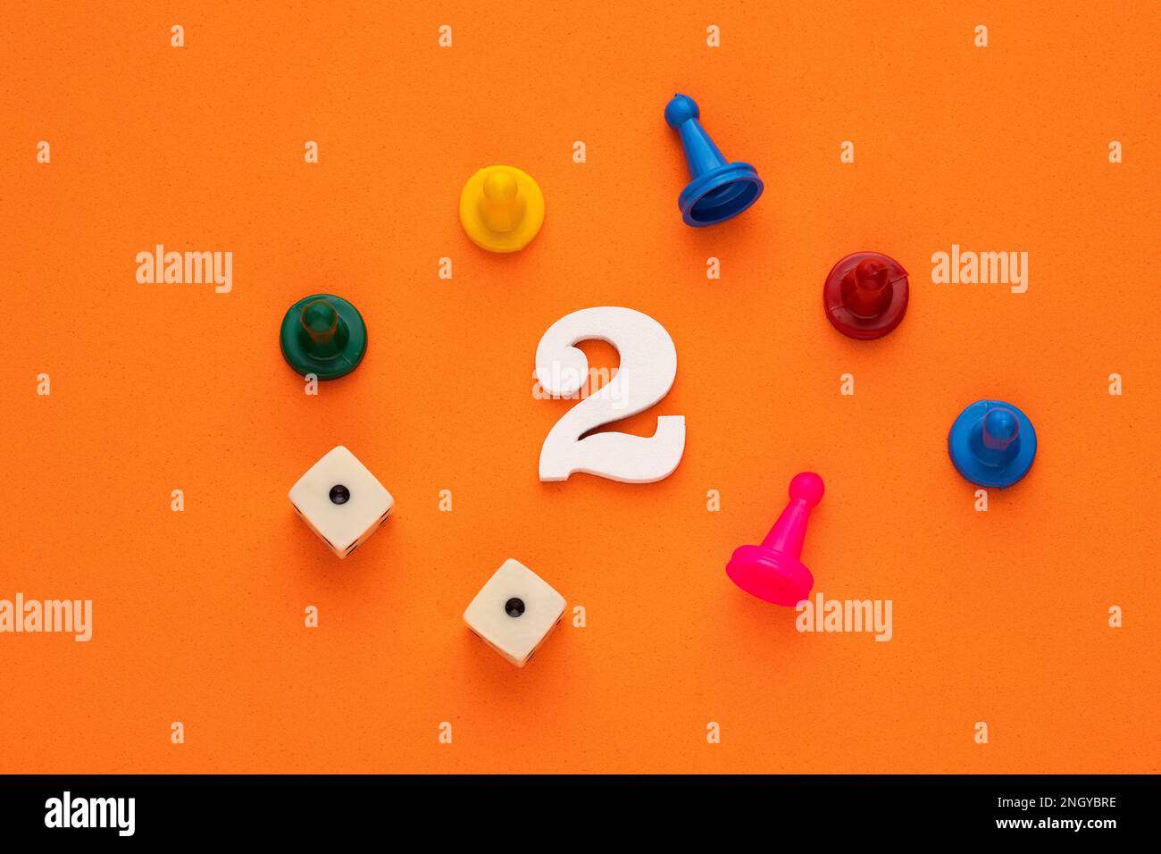 Number 2 with dice and board game pieces - Orange eva rubber background Stock Photo - Alamy