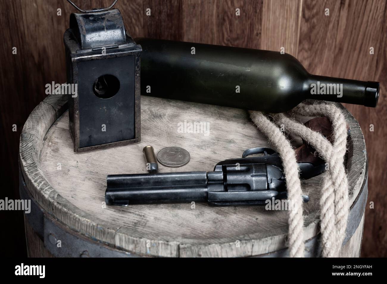 Old west revolver with cartridge and silver dollar on wooden barrel ...