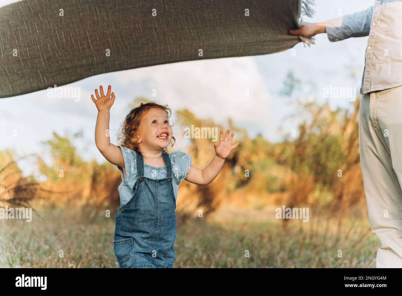 Cute 2 years old girl under waving blanket Stock Photo - Alamy