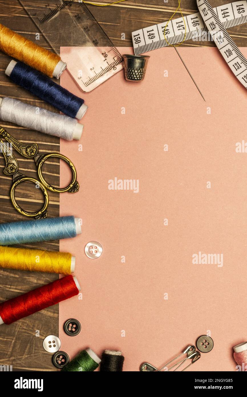 A composition of sewing supplies with many spools of colored thread ...
