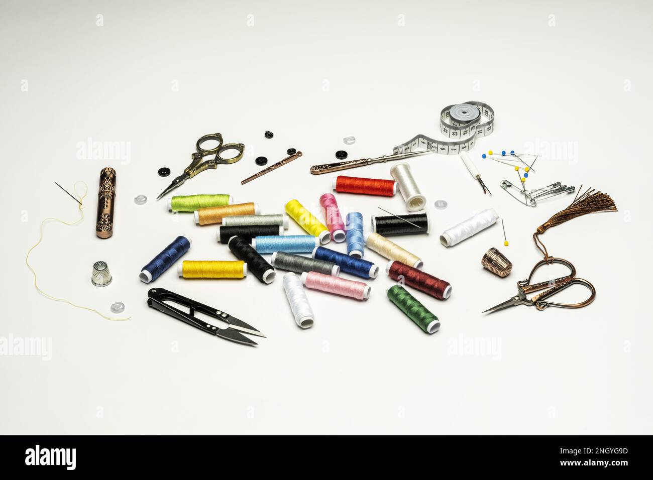 Sewing still life with spools of colored threads on white background ...