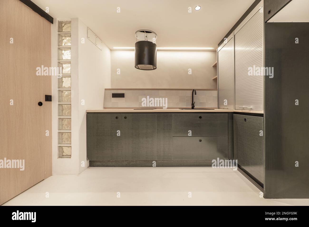 Front of a kitchen with green cabinets, black handles, cupboard with ...