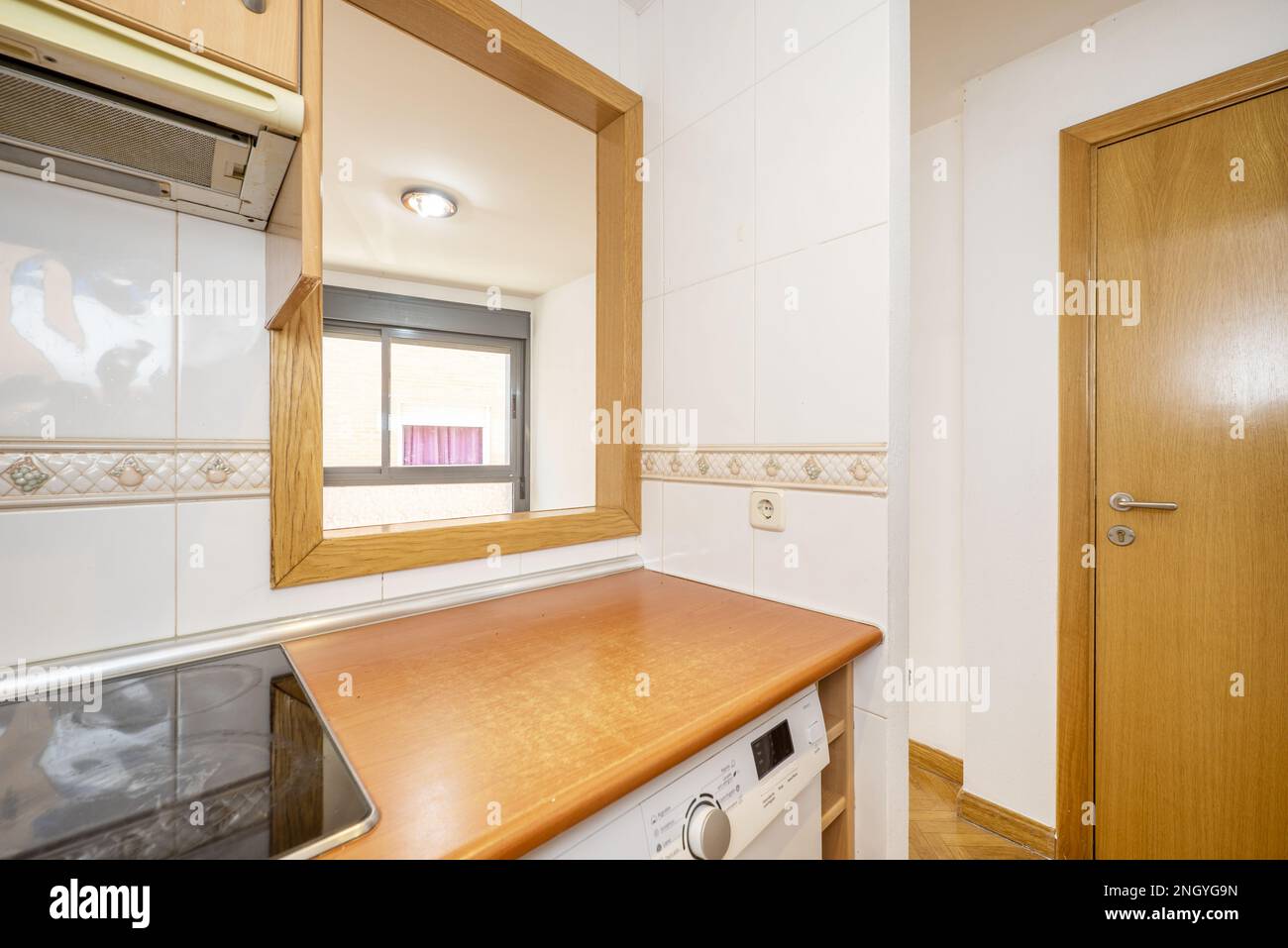 Corner of a small apartment kitchen with a hatch window to the living ...