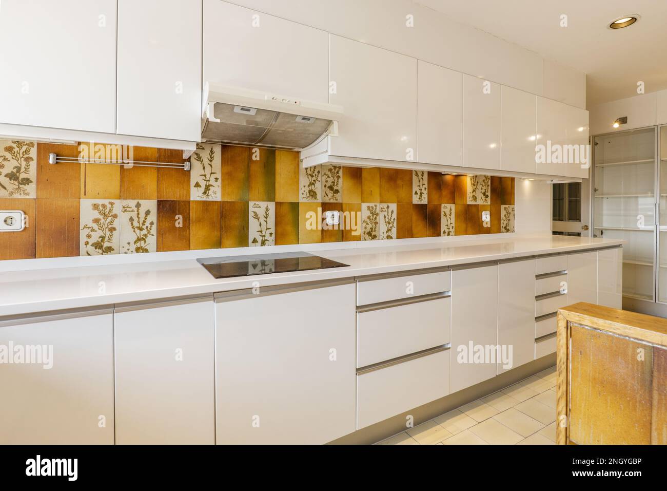 elongated kitchen with smooth white cabinets, white faux stone ...