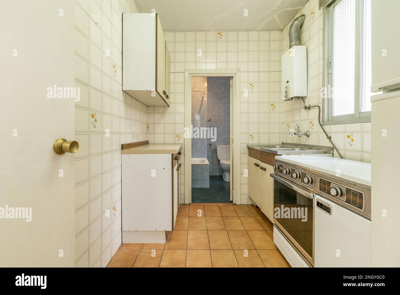 Old kitchen with old furniture in poor condition and access to a toilet ...