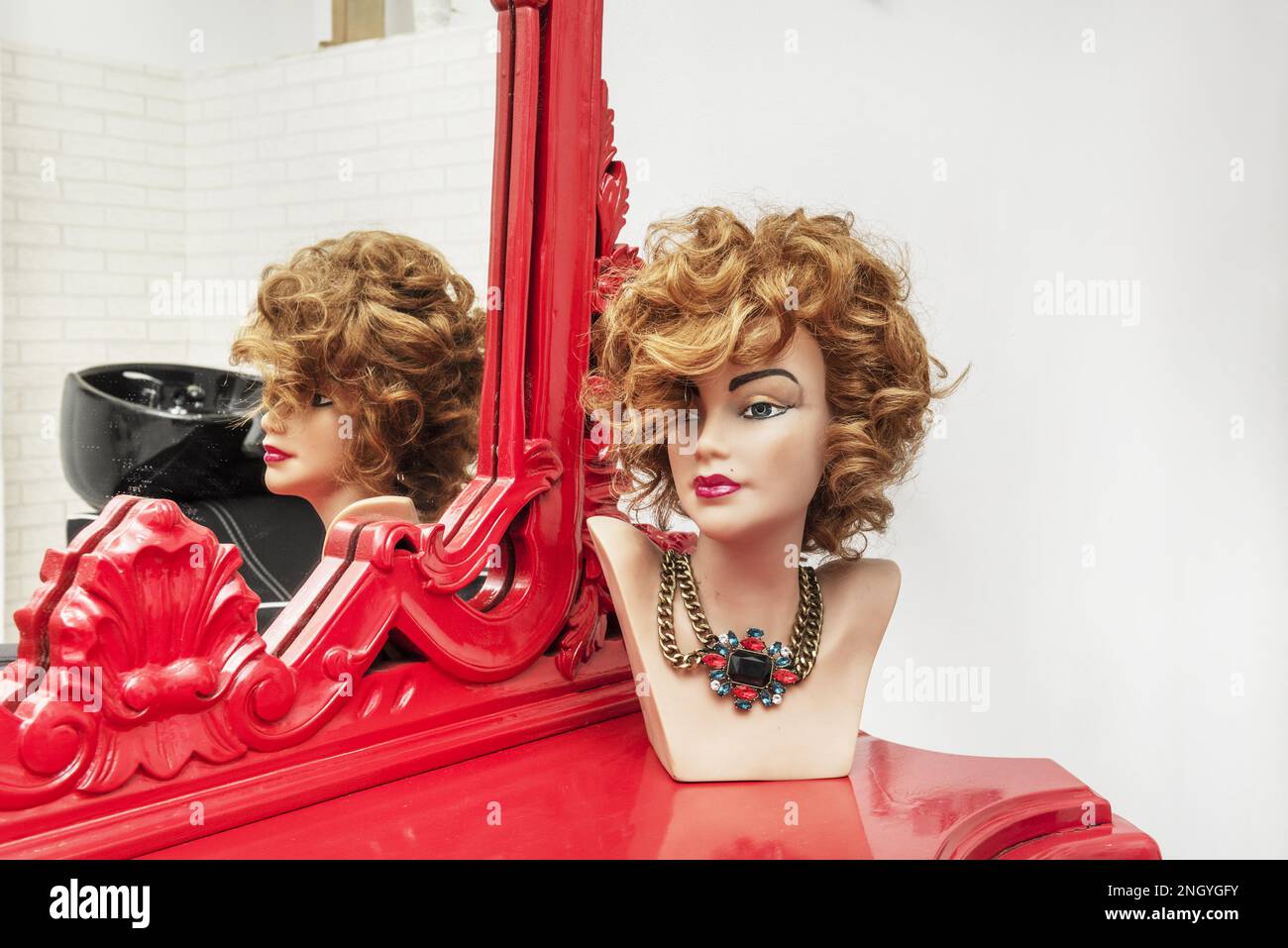 Silicone bust with a woman's face and blonde wavy wig on a red ...