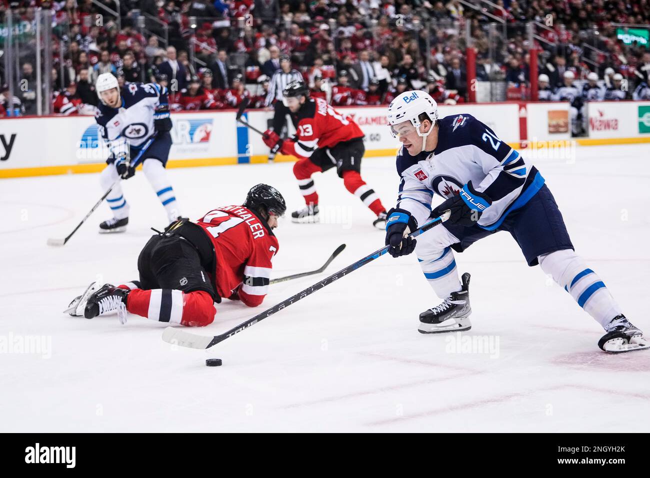 Winnipeg Jets' Karson Kuhlman (20) drives past New Jersey Devils' Jonas ...