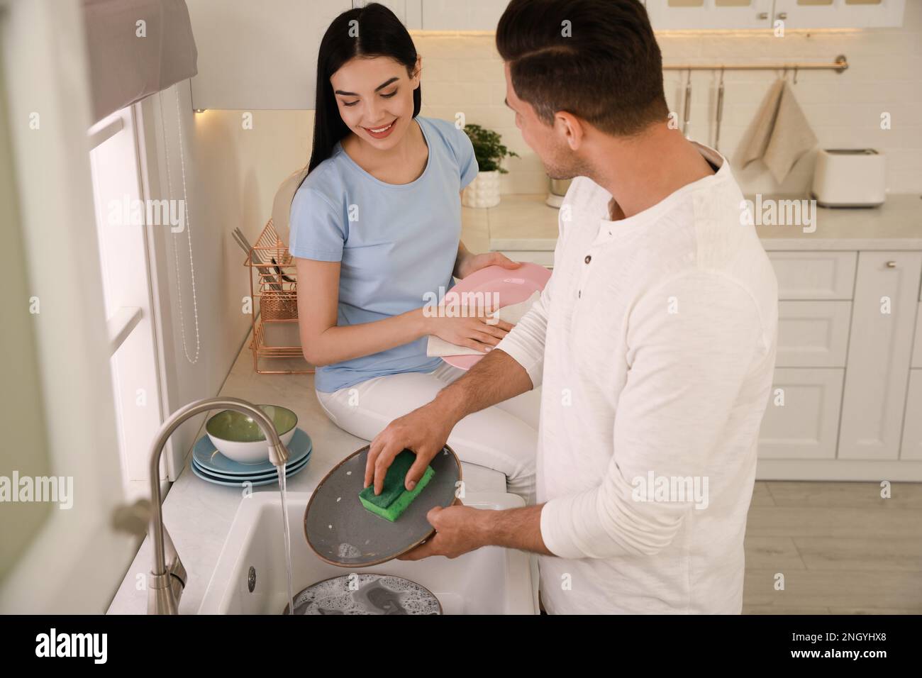 Happy lovely couple washing dishes in kitchen Stock Photo - Alamy