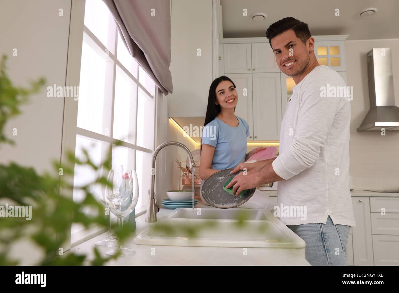 Happy lovely couple washing dishes in kitchen Stock Photo - Alamy