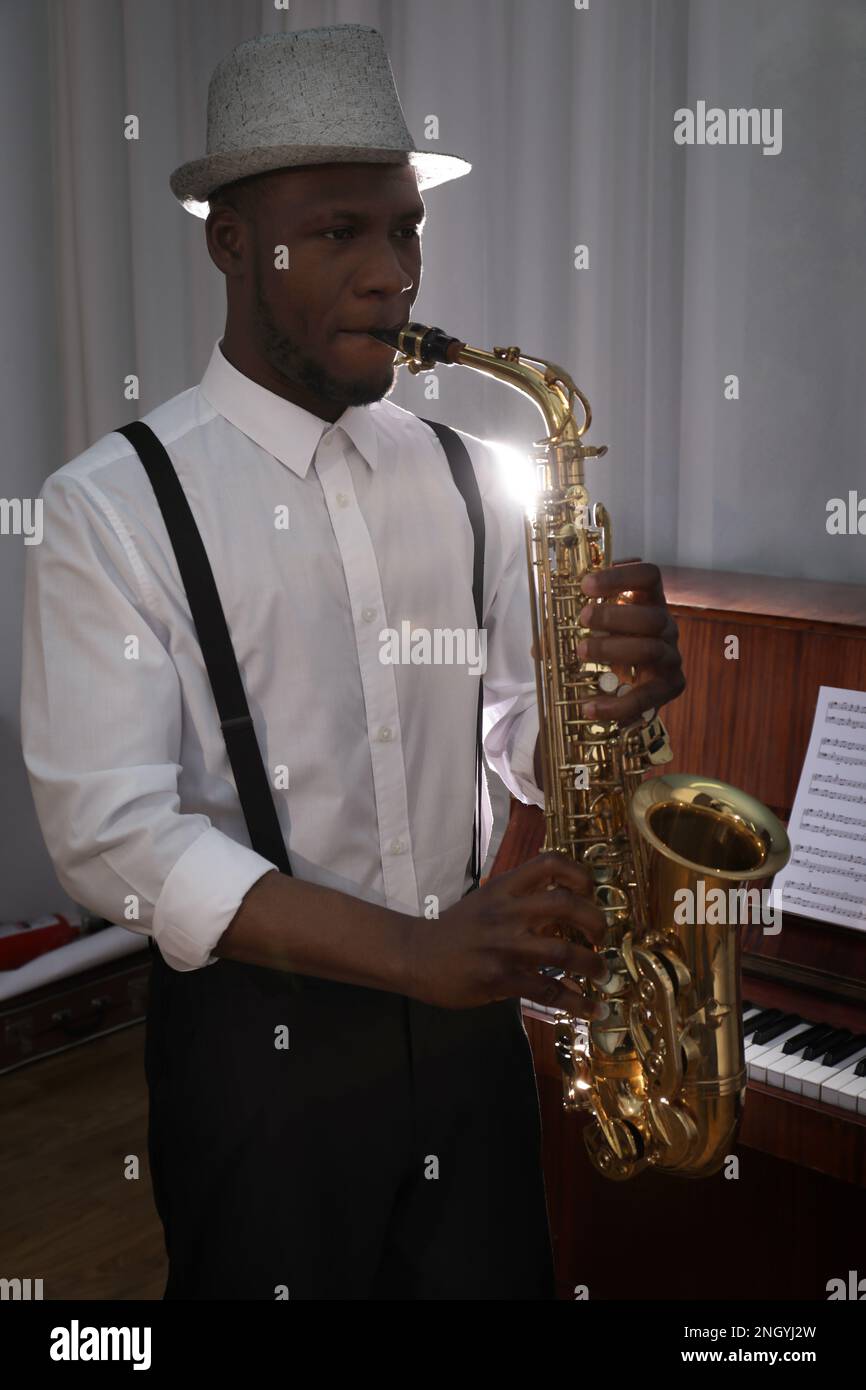 African-American man playing saxophone indoors. Talented musician Stock ...