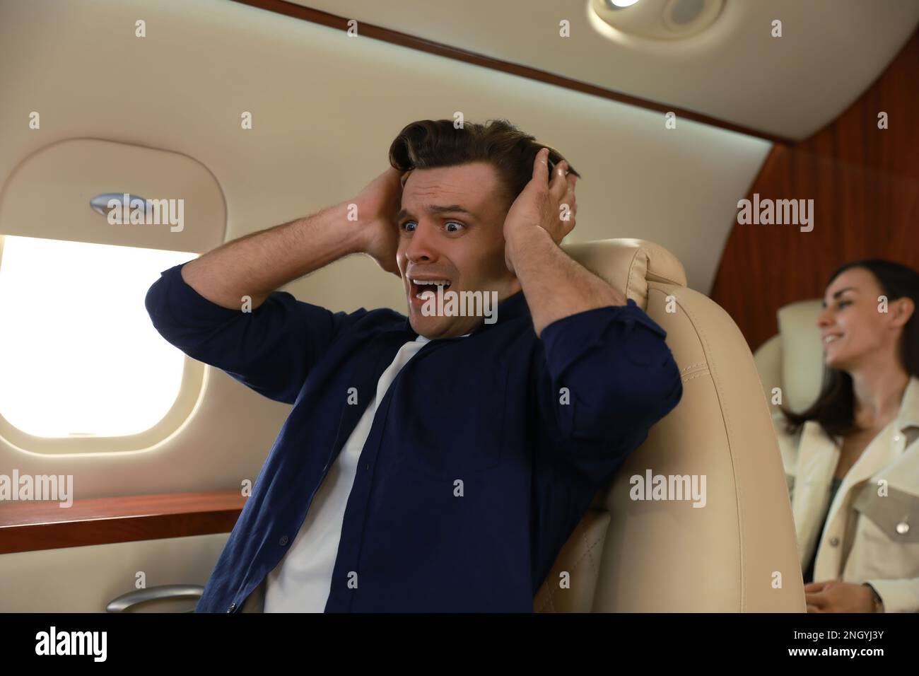 Scared young man suffering from aviophobia in airplane Stock Photo - Alamy